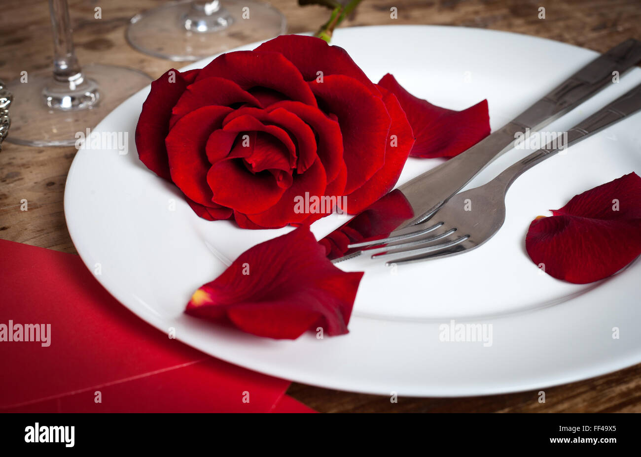 Table setting with red roses on plate - celebrating Valentine's Stock ...
