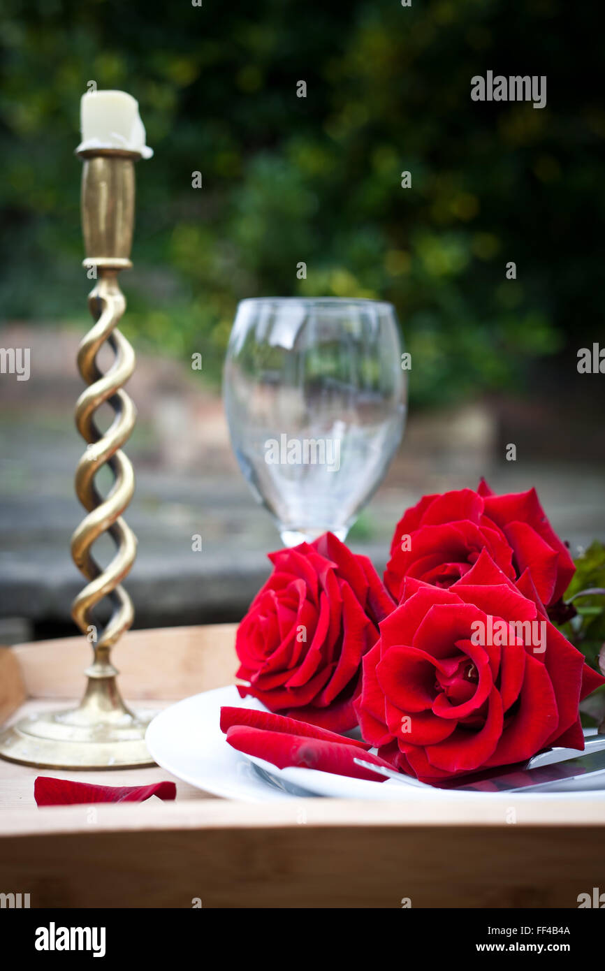 Table setting with red roses on plate - celebrating Valentine's Stock ...