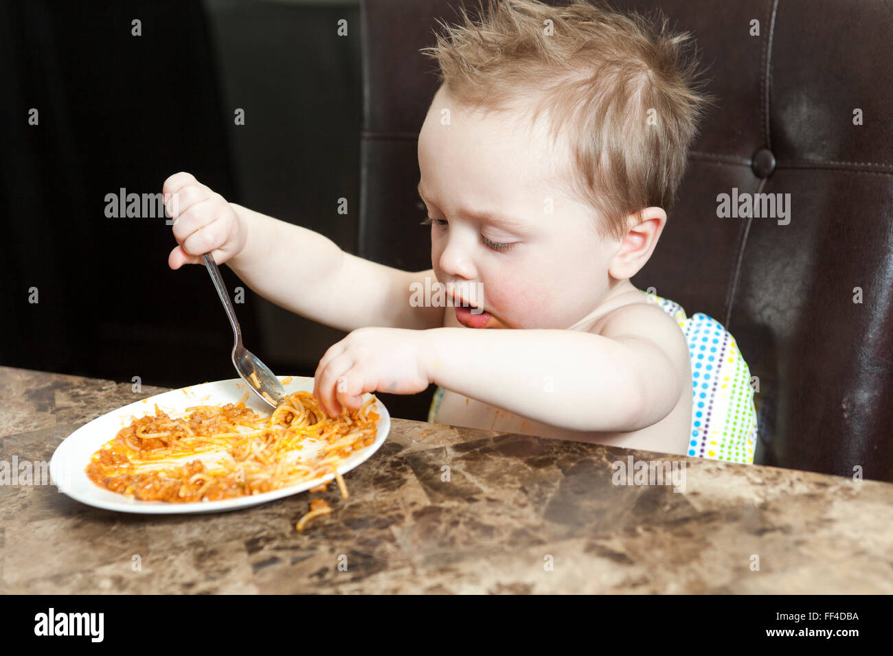 Adorable little boy eating pasta indoor. Toddler child in domestic ...