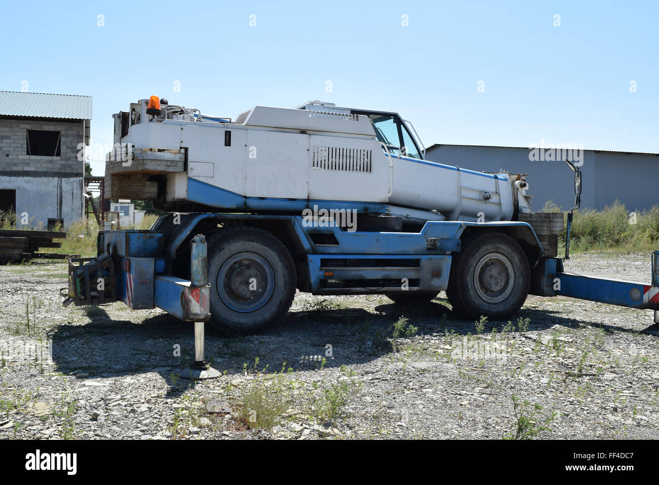 The disassembled loader crane. Old machinery repair Stock Photo - Alamy