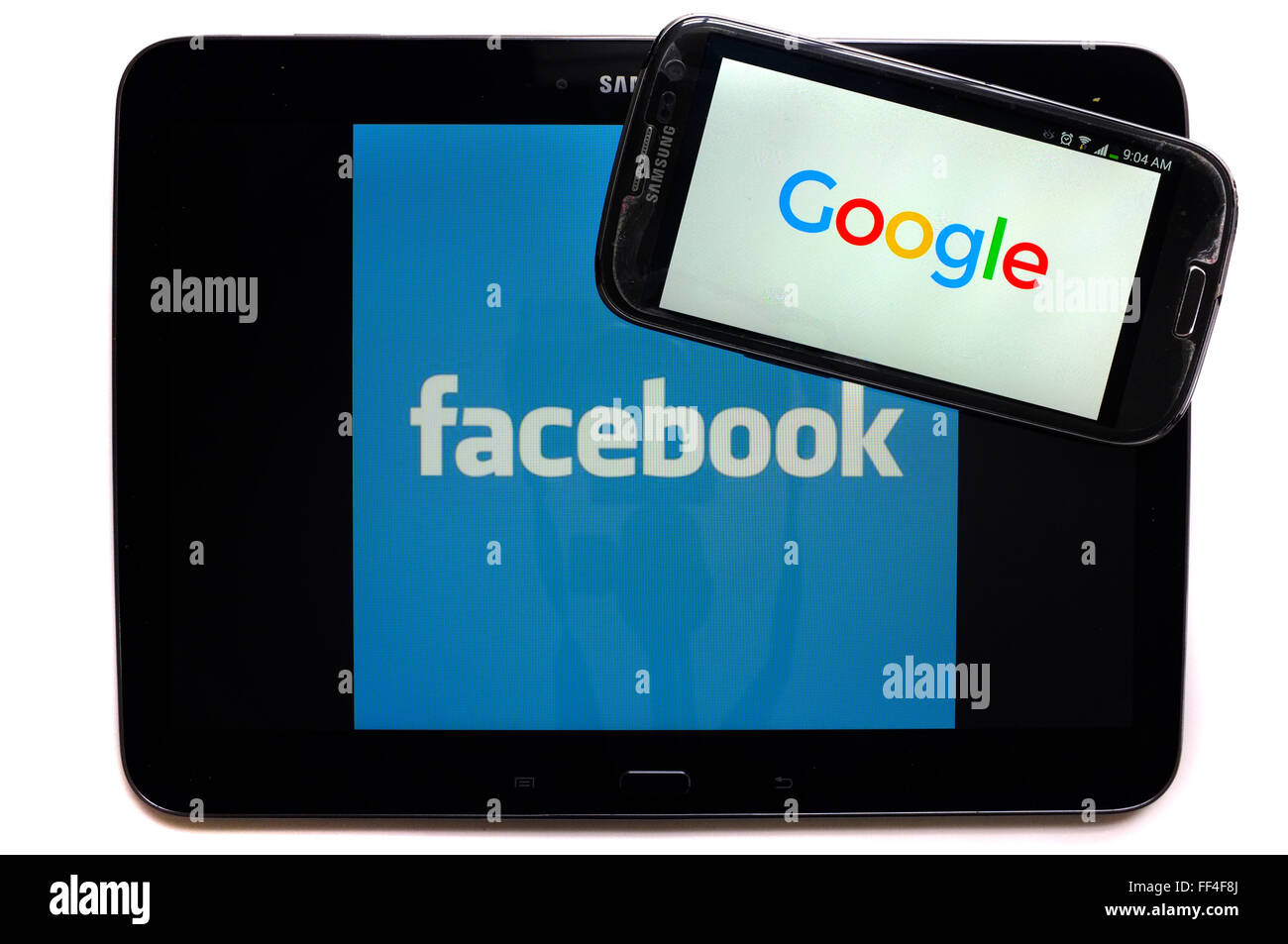 The Google logo on a smartphone and Facebook on a tablet photographed ...