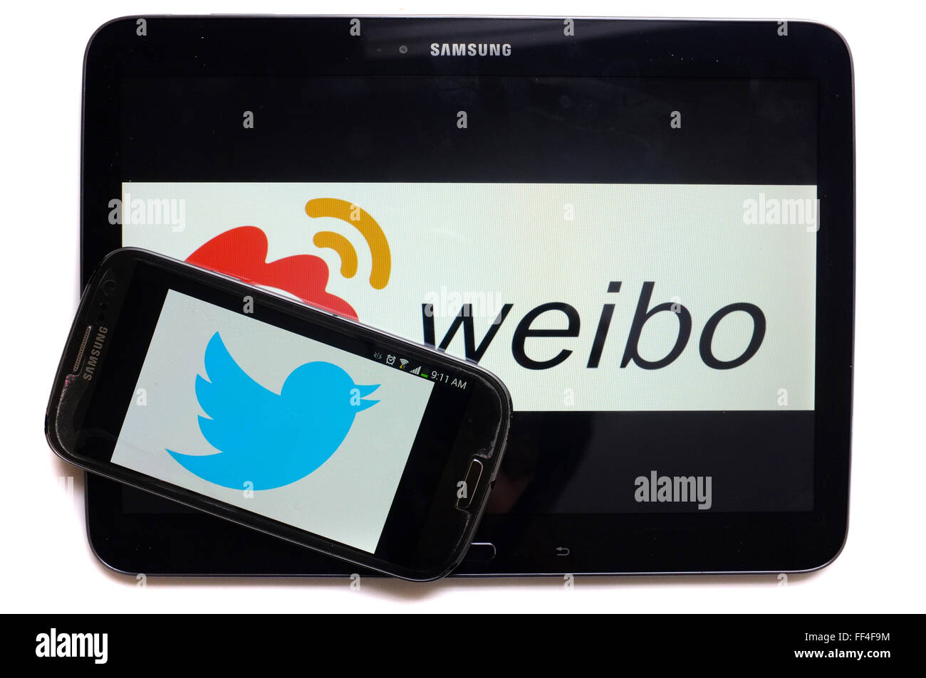 The Twitter logo on a smartphone and Weibo on a tablet photographed ...