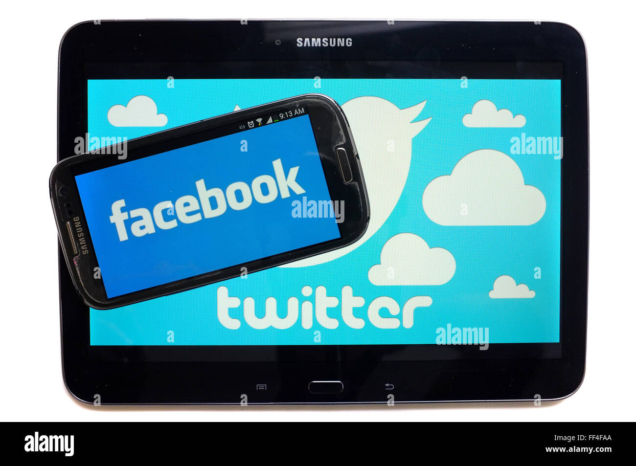The Facebook logo on a smartphone and Twitter on a tablet photographed ...