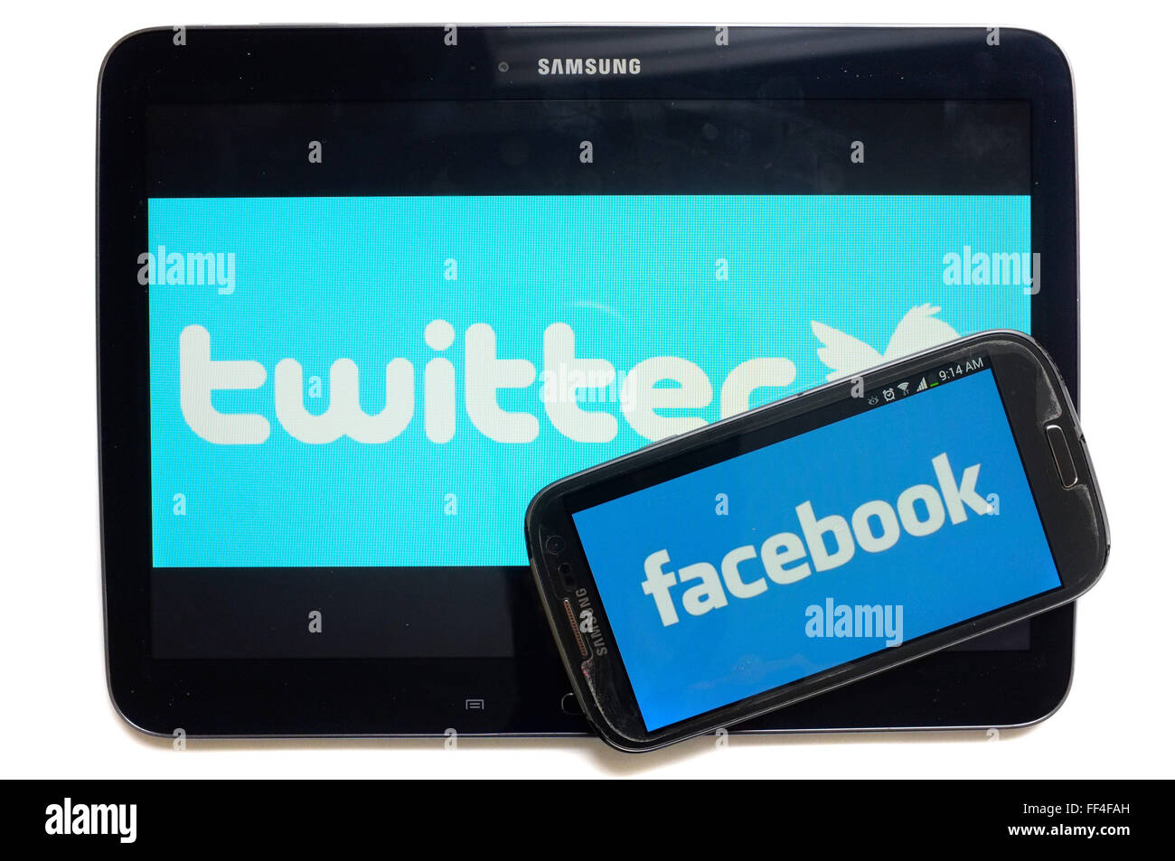 The Facebook logo on a smartphone and Twitter on a tablet photographed ...