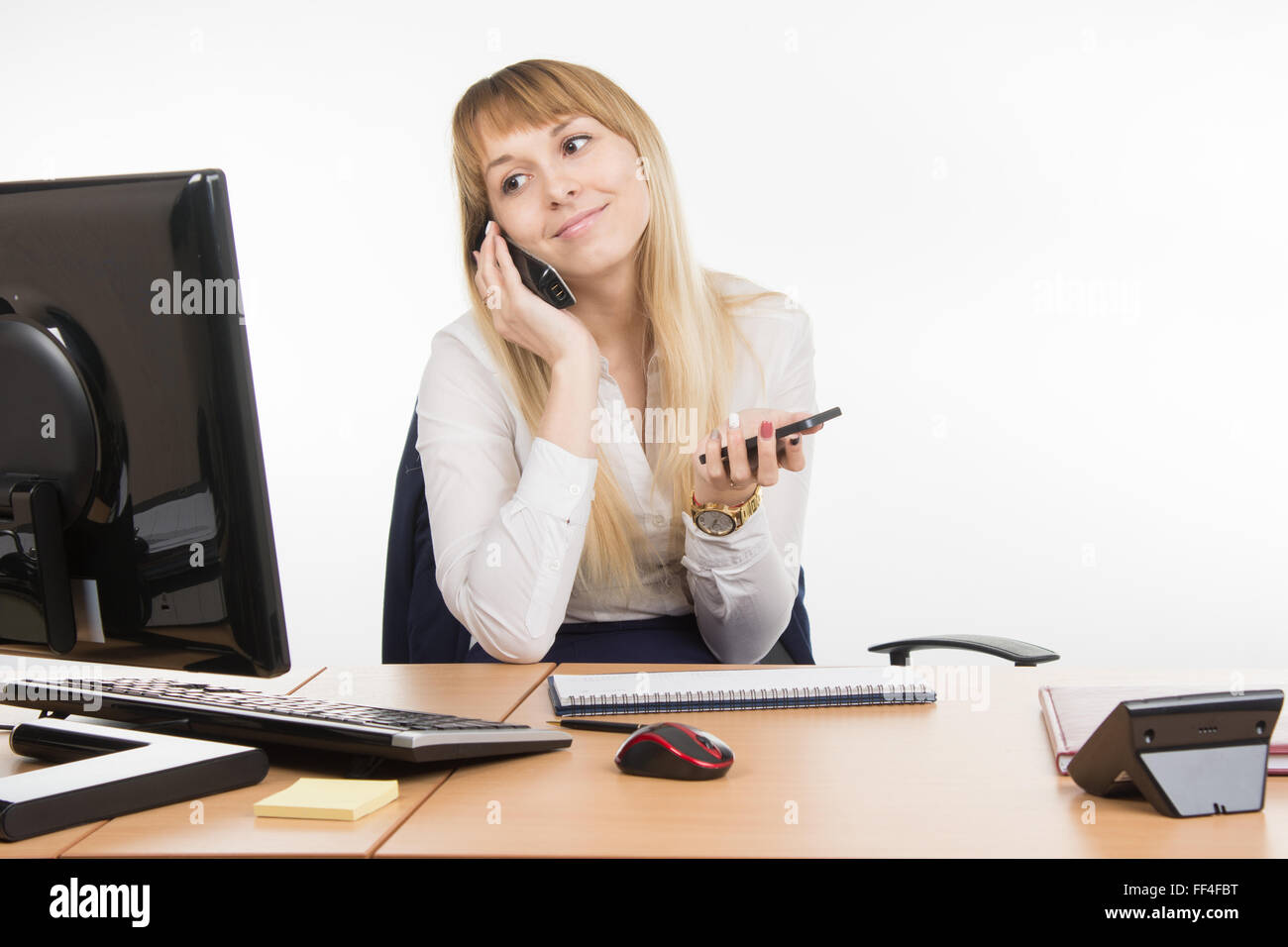 Happy secretary looked at the computer screen talking on the phone ...