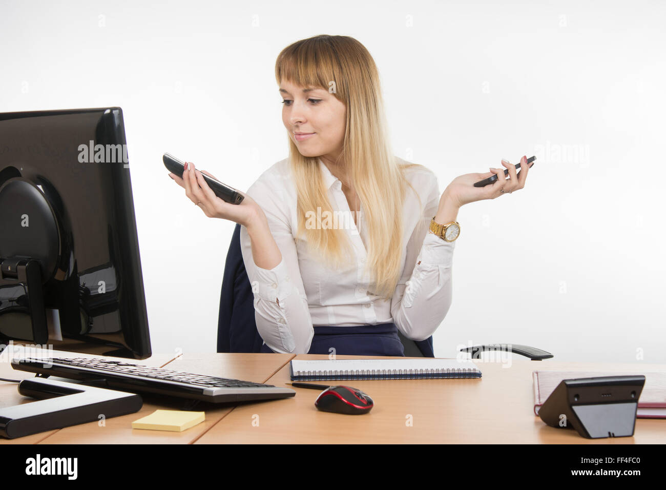 Secretary holding two phone rang and looked at work Stock Photo - Alamy