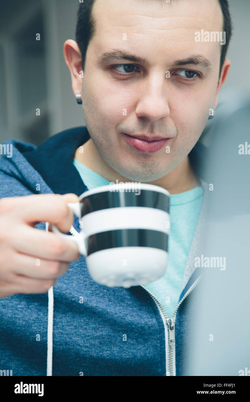 Young man drinking coffee and working Stock Photo - Alamy