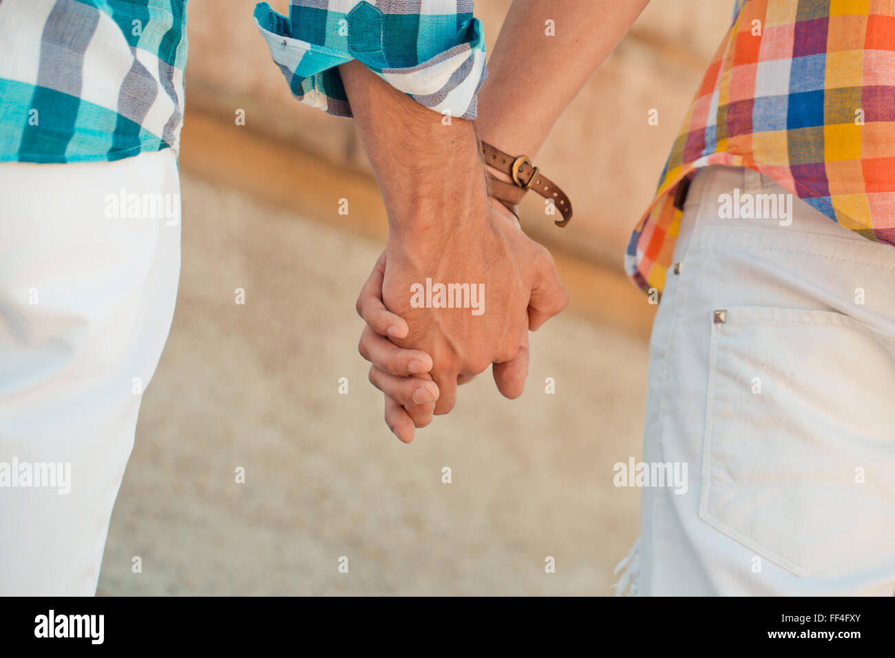 Two boyfriends in summer clothes holding hands Stock Photo - Alamy