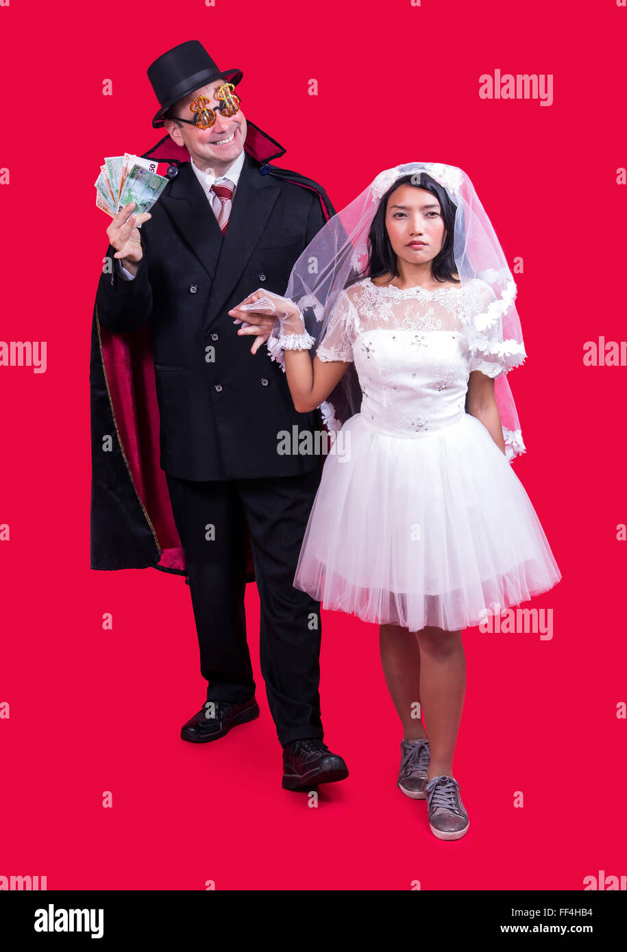 happy bride with money holds unhappy bride Stock Photo - Alamy