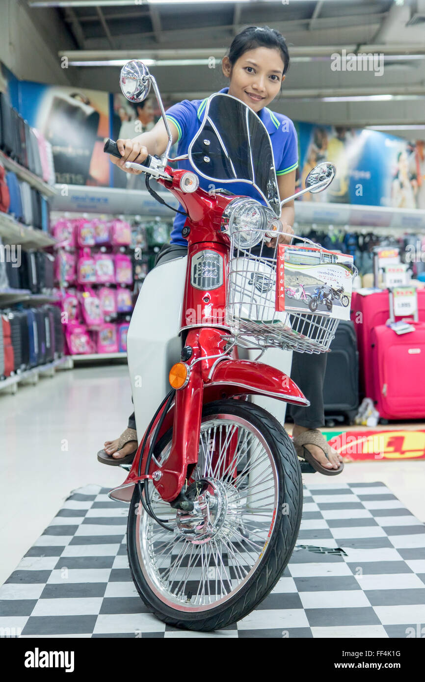 Asian woman sits on a motorcycle in the shop Stock Photo - Alamy
