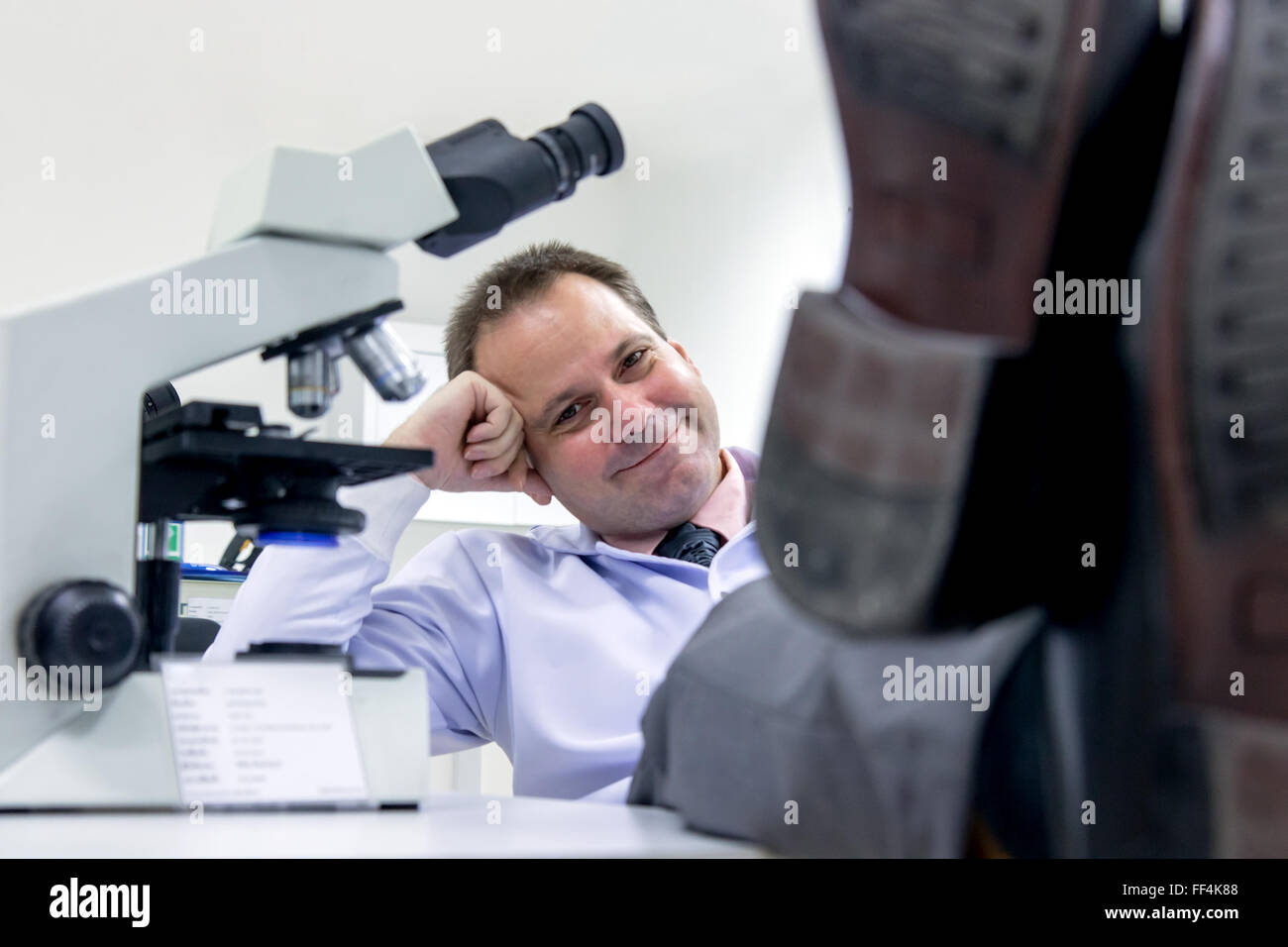 Resting doctor in a laboratory has his feet on the desk Stock Photo - Alamy