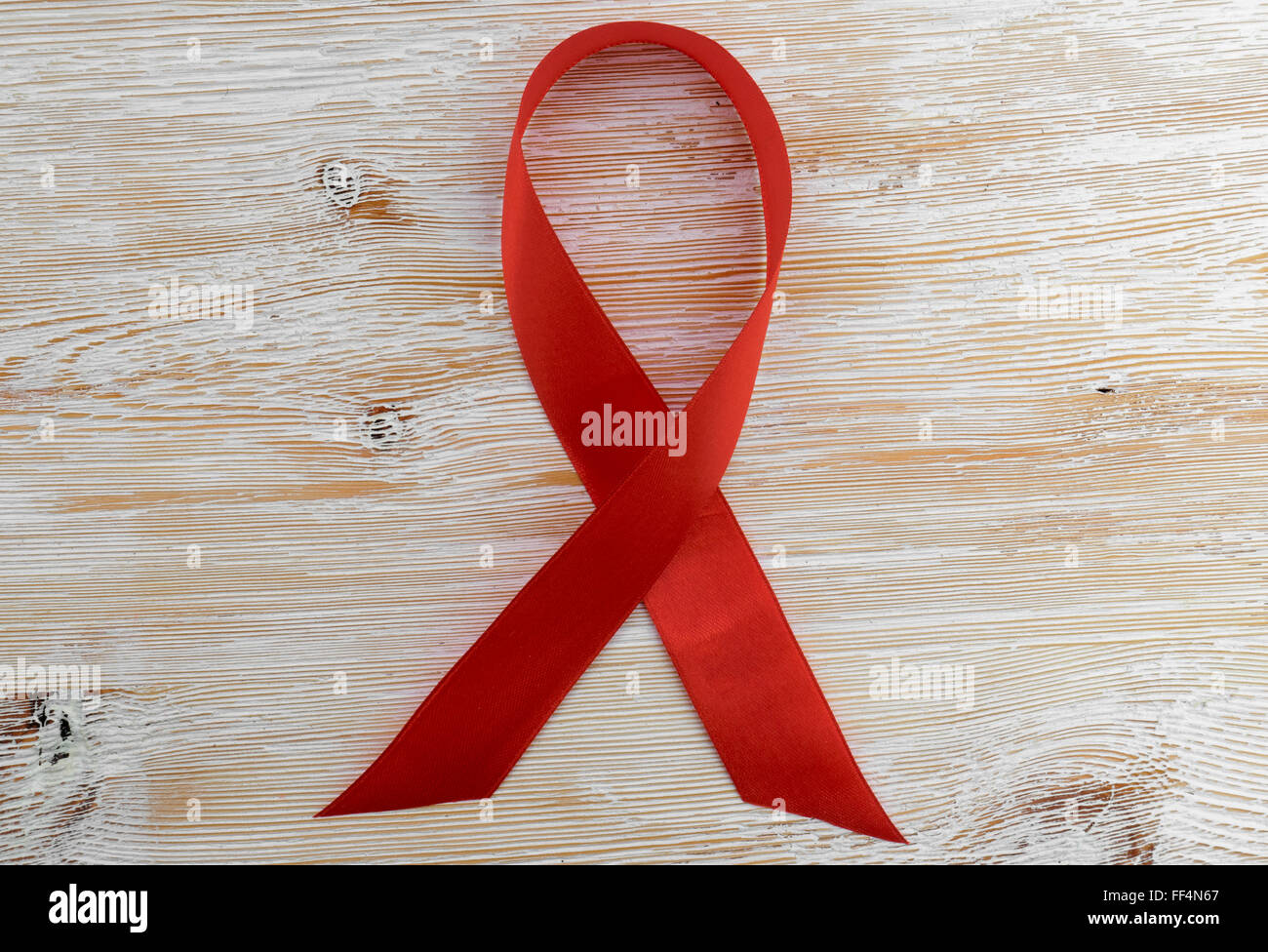 Red ribbon HIV, AIDS on wooden background Stock Photo - Alamy