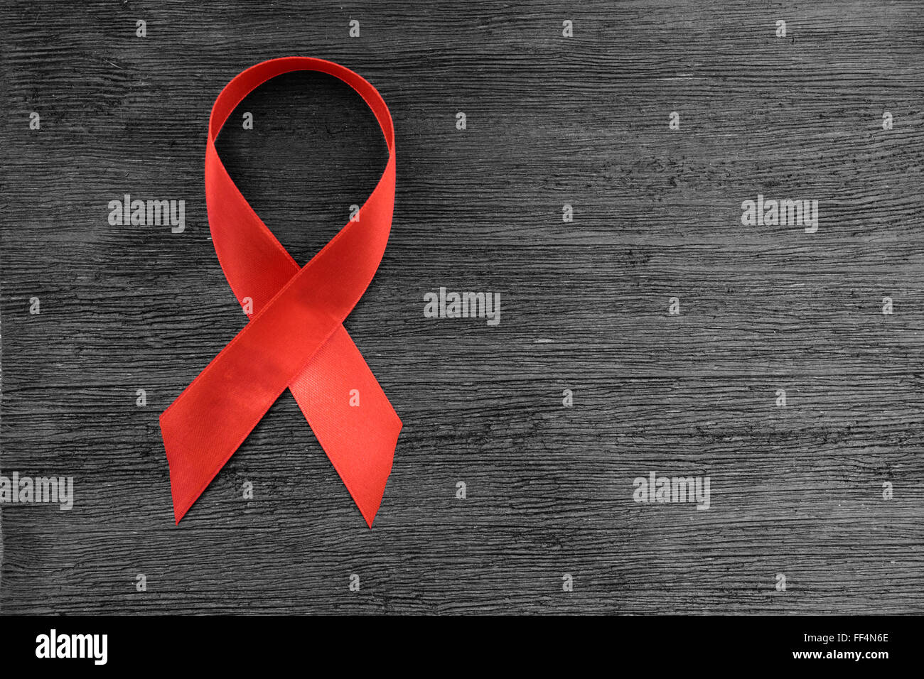 Red ribbon HIV, AIDS on wooden background Stock Photo - Alamy