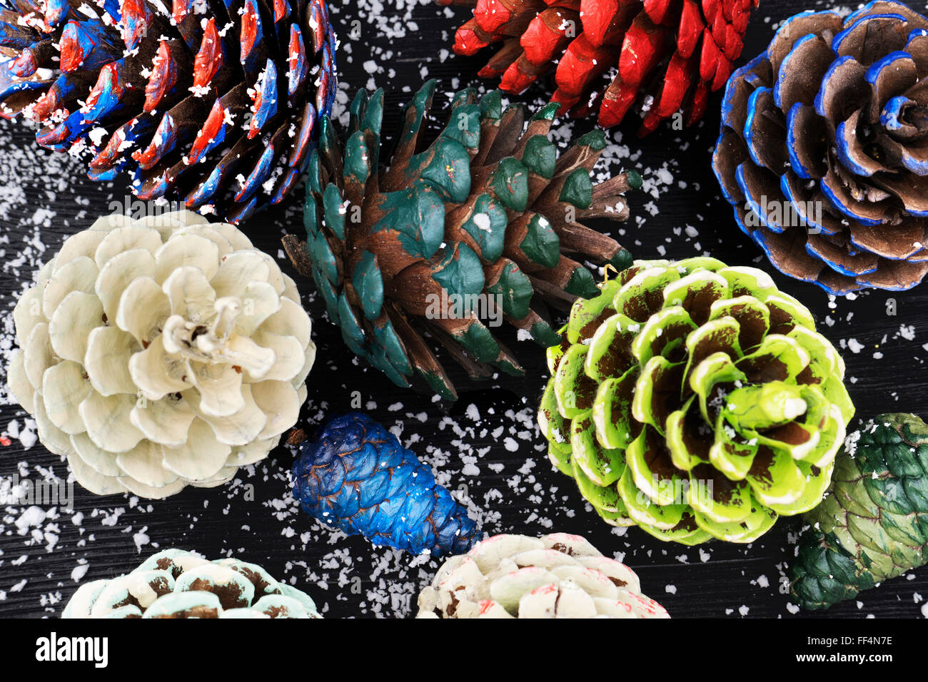 Pinecones painted with different paints, isolated on black background ...