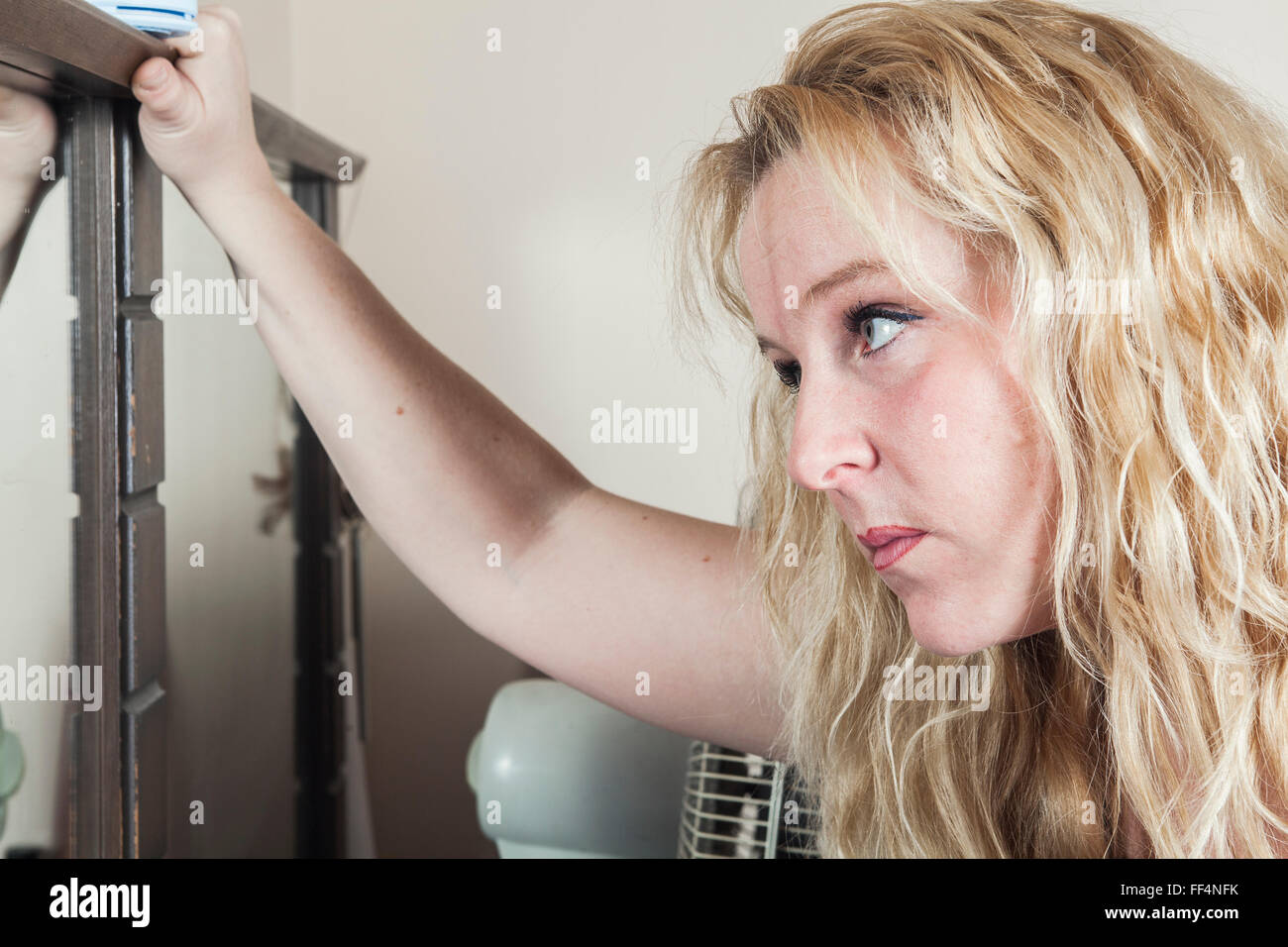 Young sad woman looking in the mirror Stock Photo - Alamy