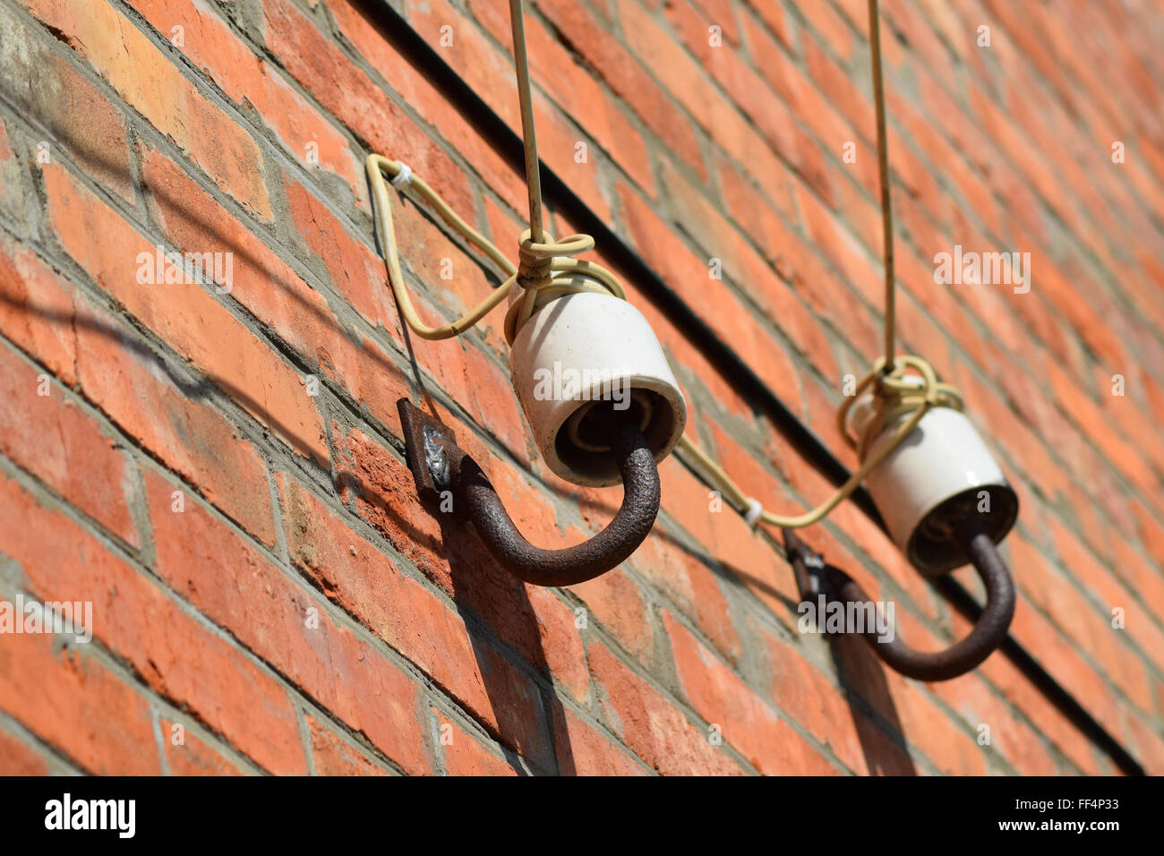 Ceramic insulators on the wall. Connection wiring Stock Photo - Alamy
