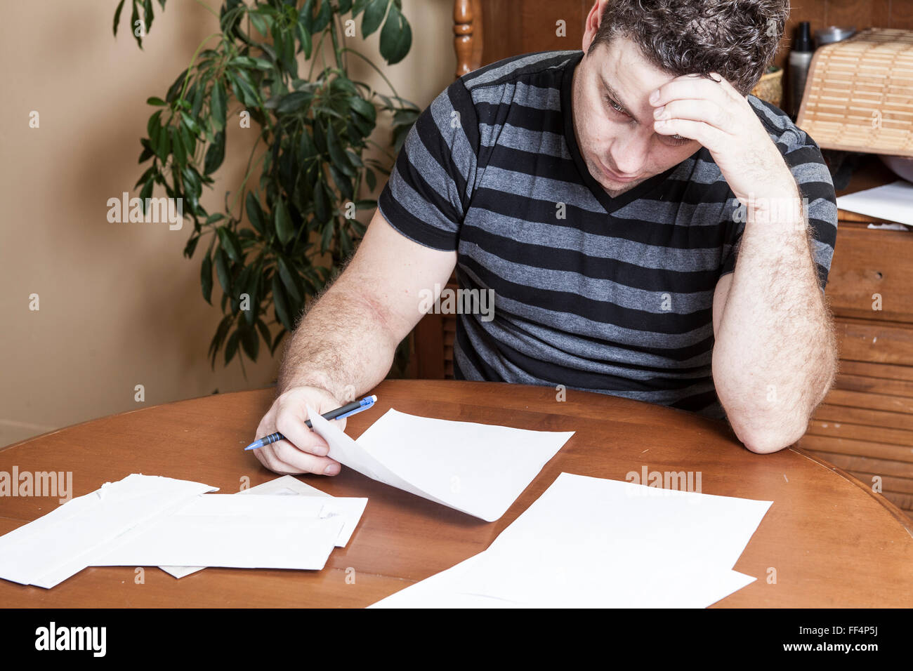 Frustrated man sits in the kitchen Stock Photo - Alamy