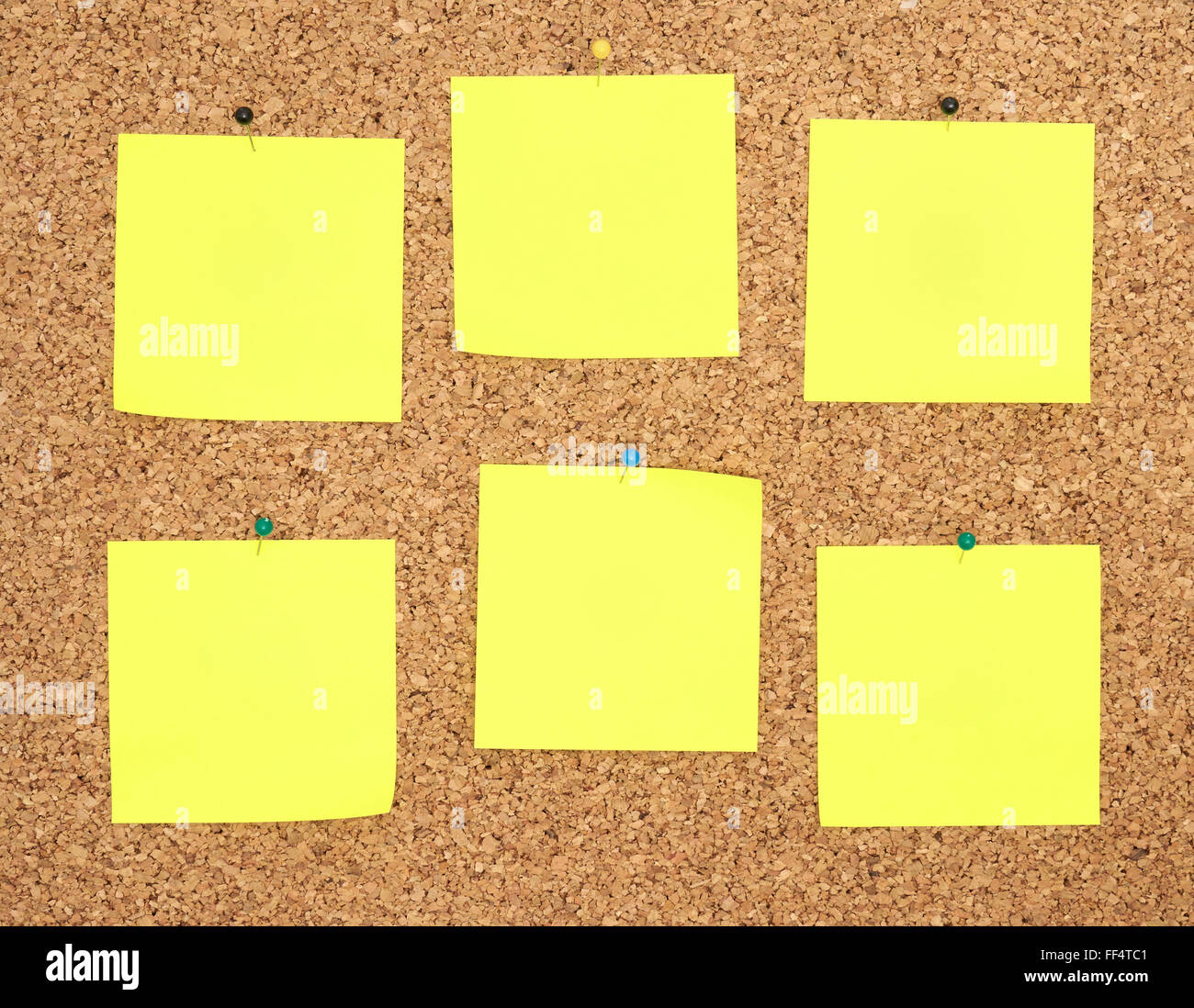 Yellow sticker notes over cork board background Stock Photo - Alamy