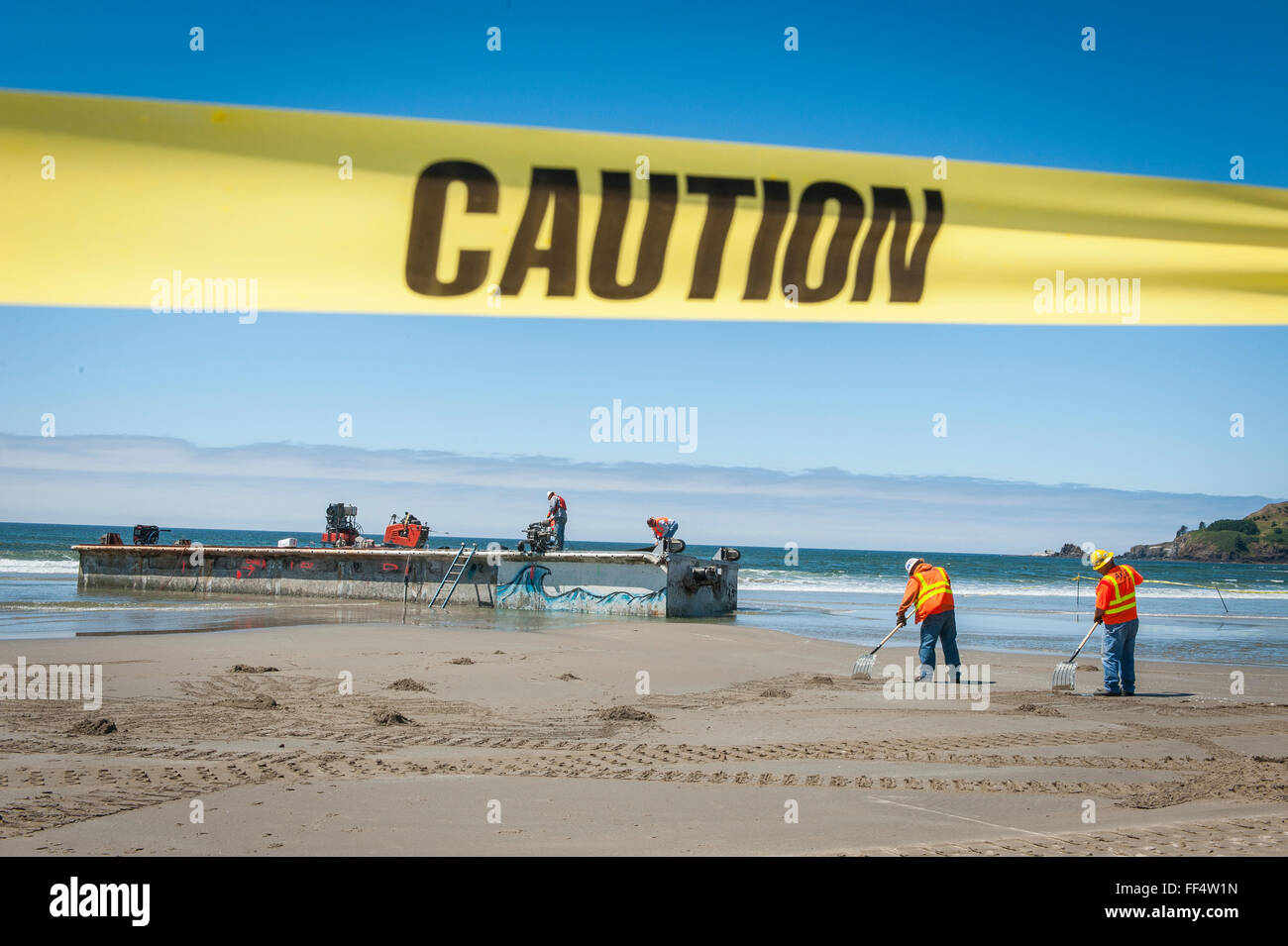 Workers remove a cement floating boat dock that had drifted across the ...