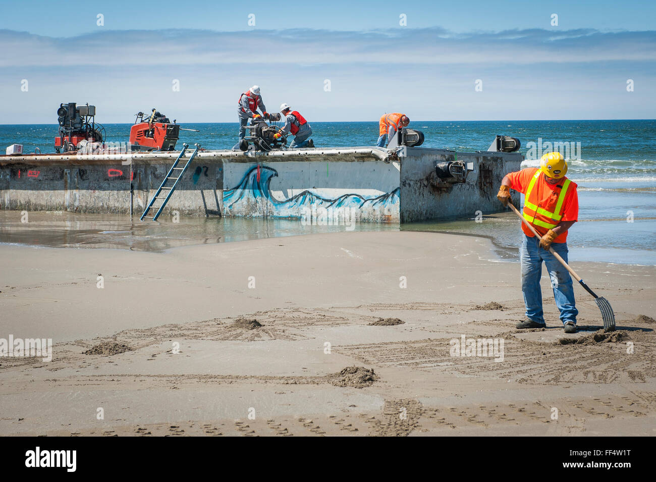 Workers remove a cement floating boat dock that had drifted across the ...