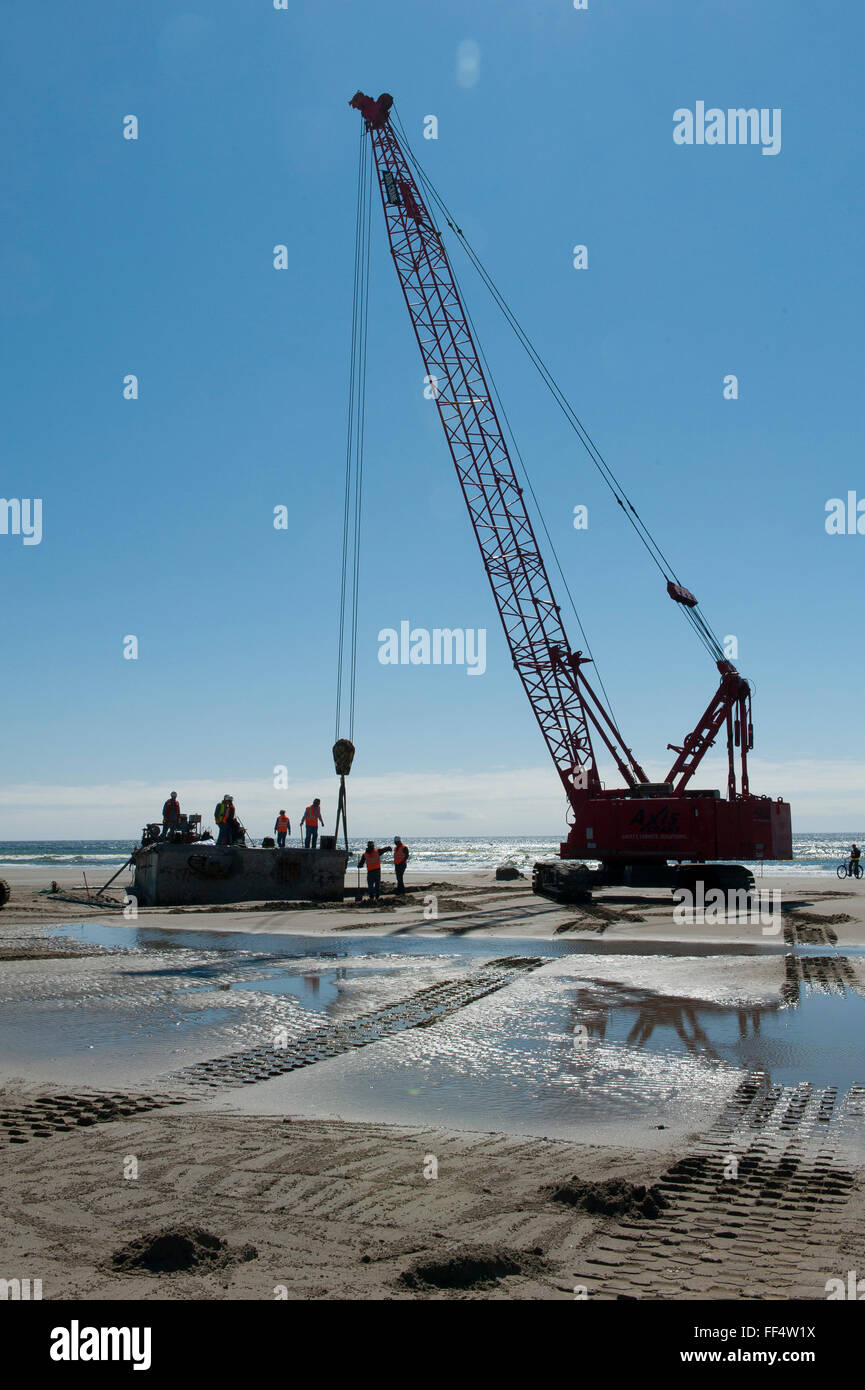 Workers remove a cement floating boat dock that had drifted across the ...