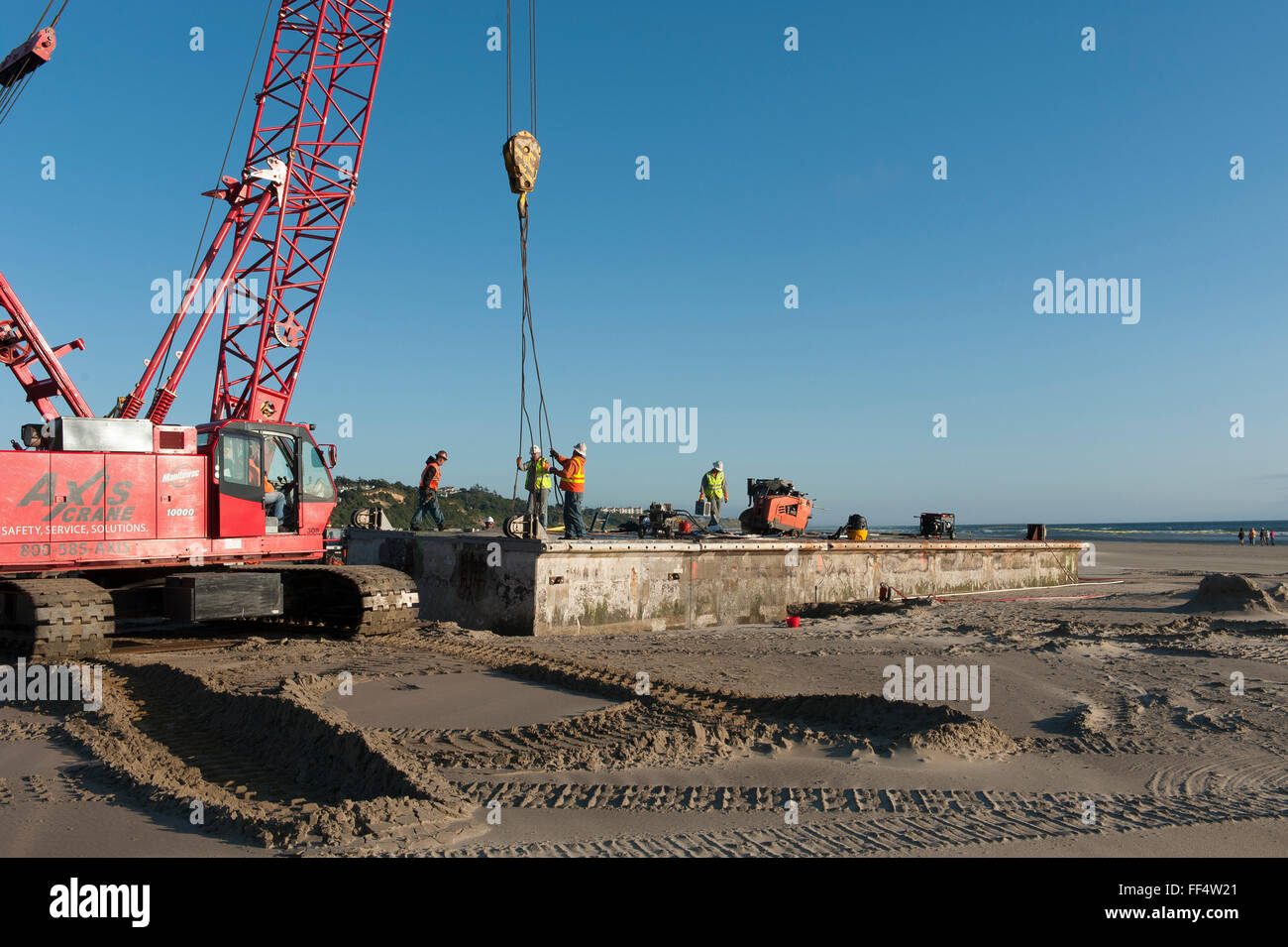 Workers remove a cement floating boat dock that had drifted across the ...