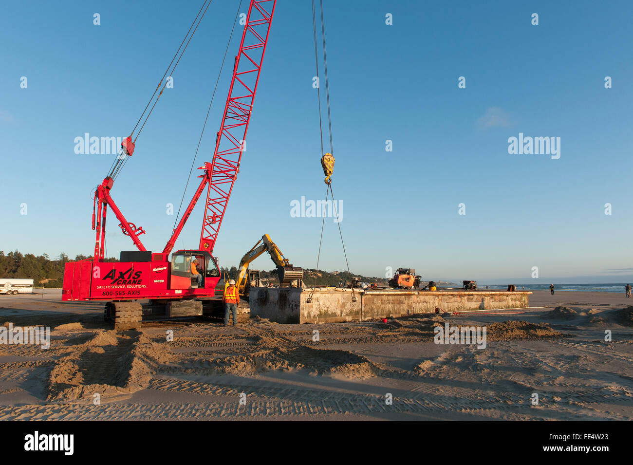 Workers remove a cement floating boat dock that had drifted across the ...