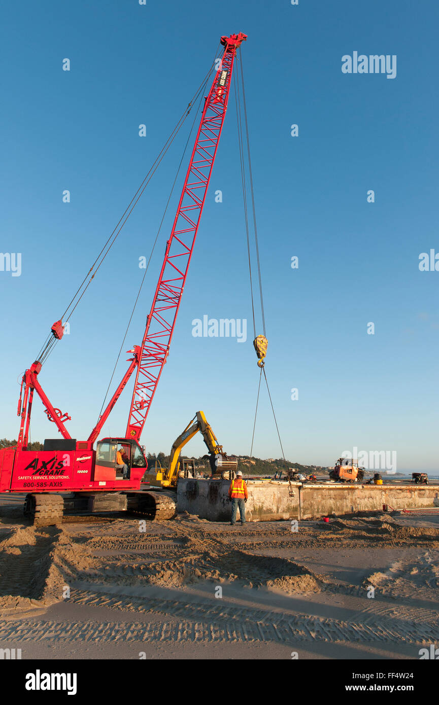 Workers remove a cement floating boat dock that had drifted across the ...