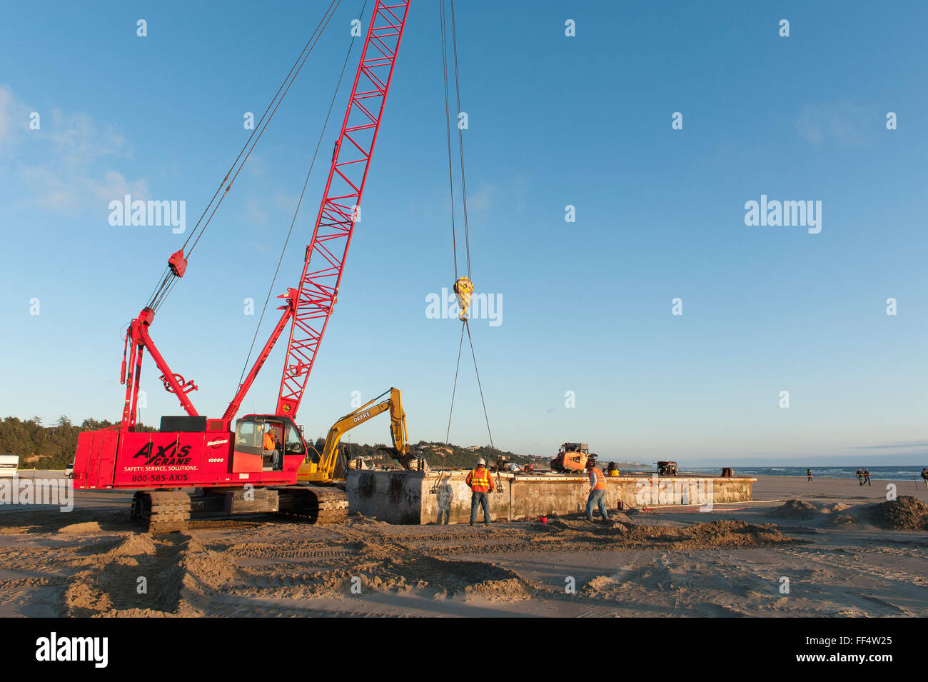 Workers remove a cement floating boat dock that had drifted across the ...