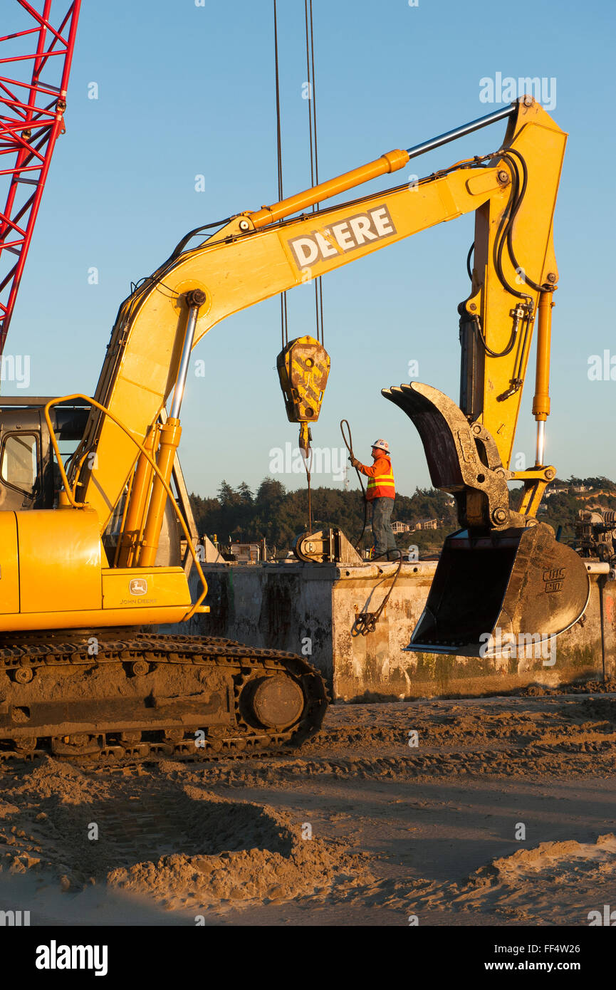 Workers remove a cement floating boat dock that had drifted across the ...
