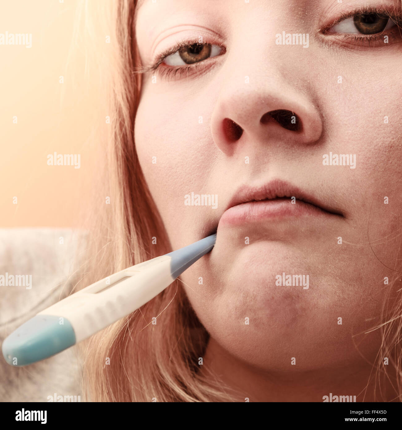 Sick ill woman with digital thermometer in mouth. Young girl having ...