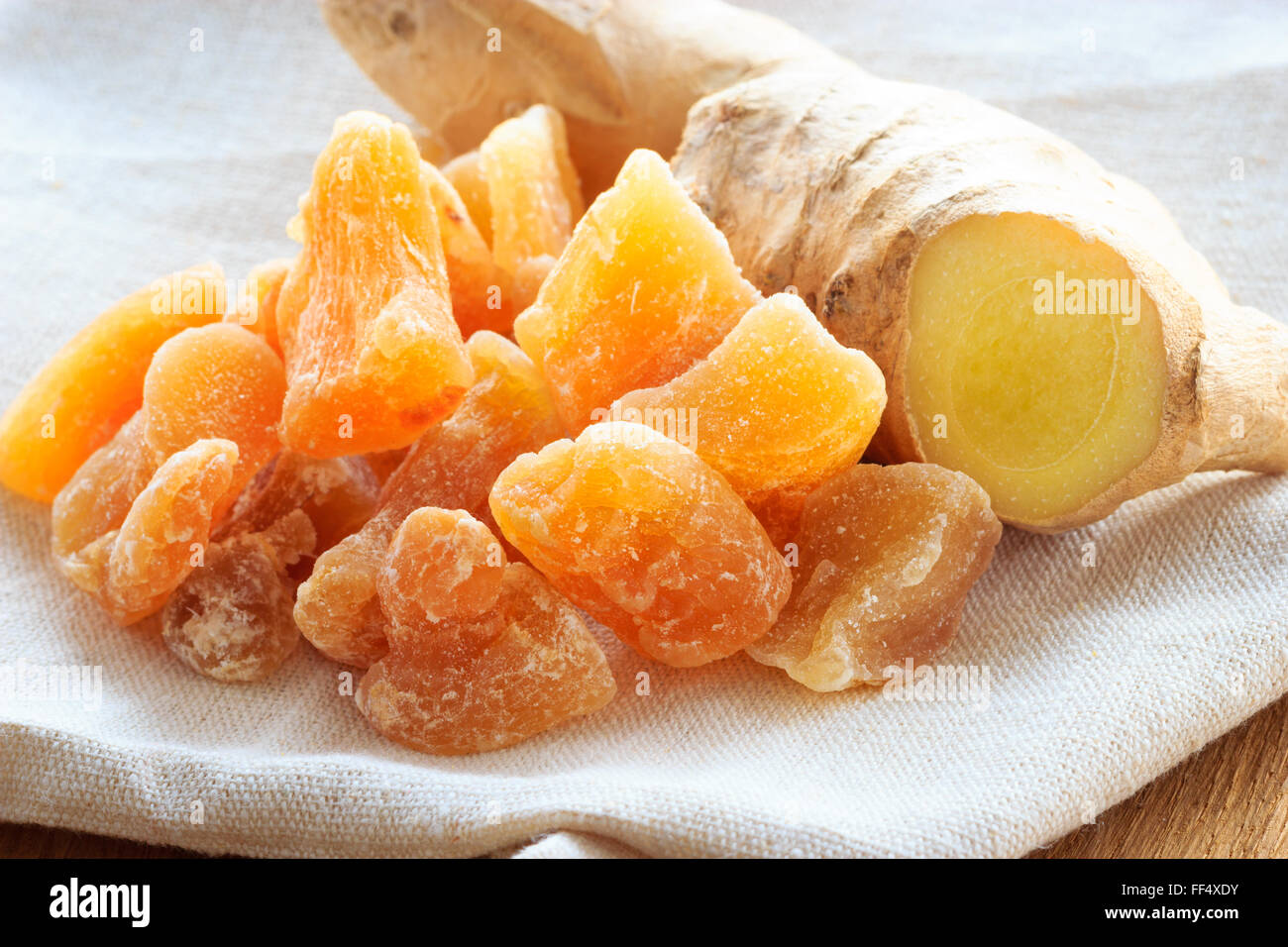 Closeup dried candied crystallized ginger pieces and fresh rhizome root ...