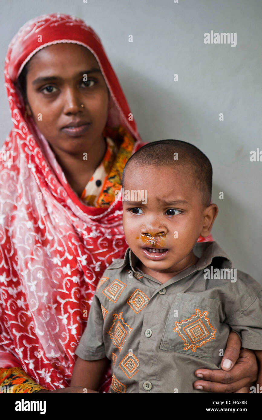 Asma and her 2 year old son, Imran, wait to have a check up after a ...