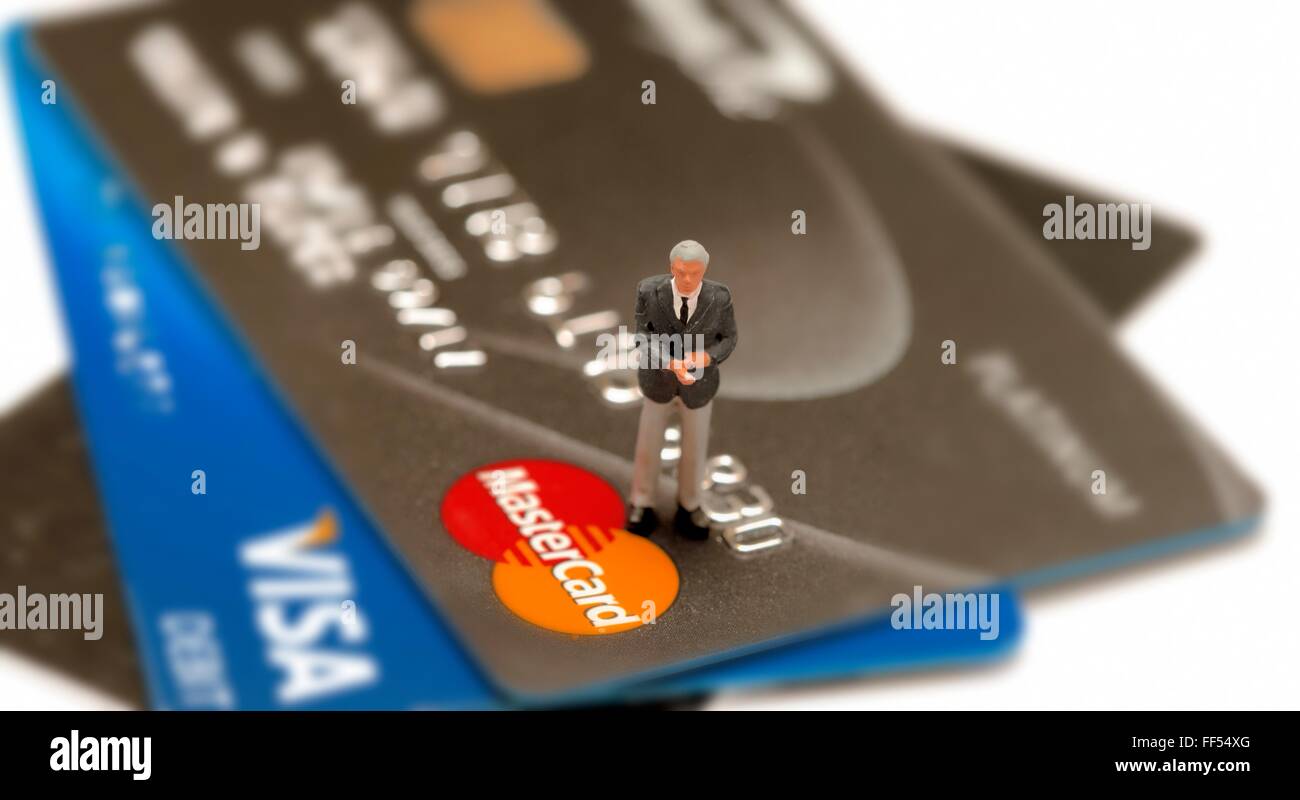 A Debit and credit card close up with a miniature figurine standing ...