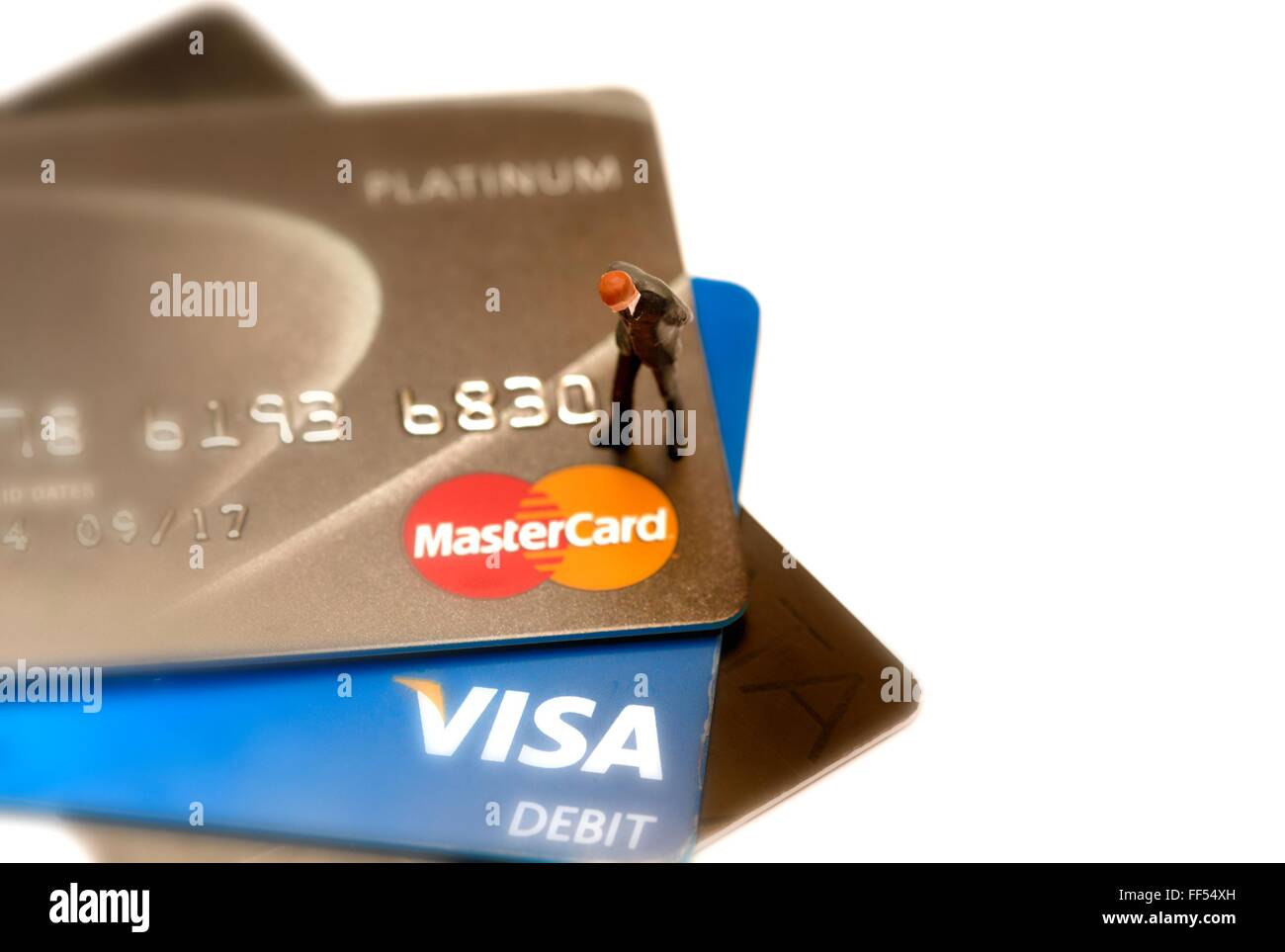 A Debit and credit card close up with a miniature figurine standing ...