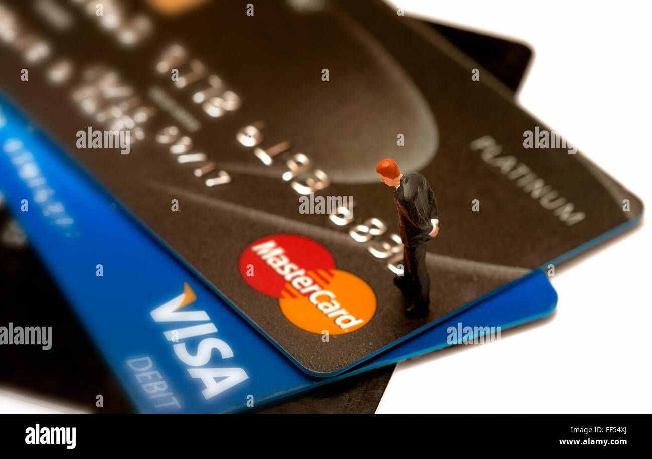 A Debit and credit card close up with a miniature figurine standing ...