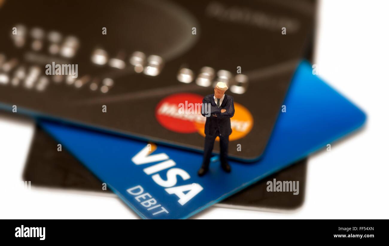 A Debit and credit card close up with a miniature figurine standing ...