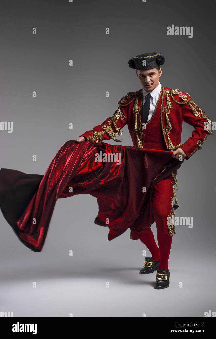 Studio shot of man dressed as Spanish torero, matador, bullfighter ...