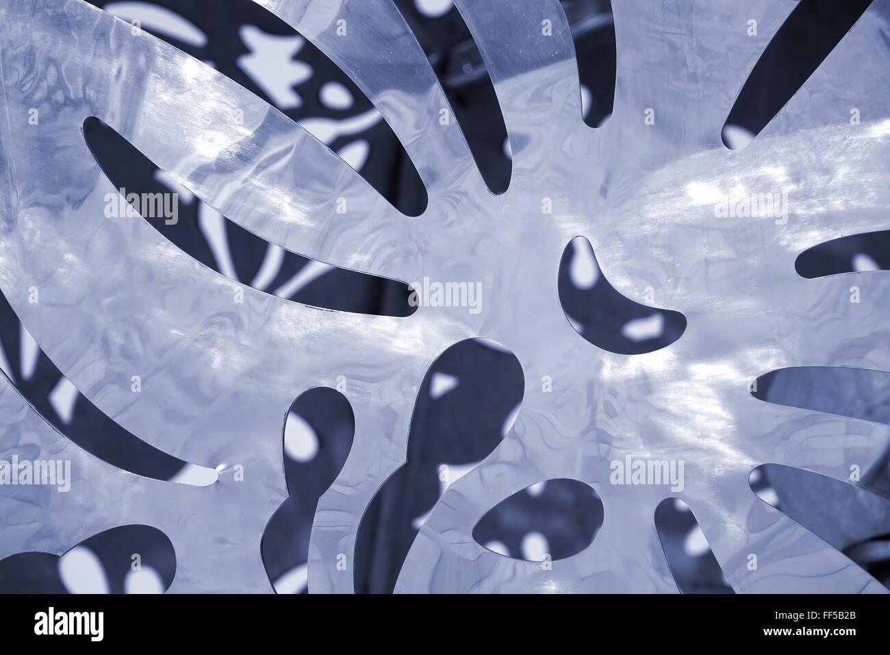 Polished steel surface with random holes that let the light through ...