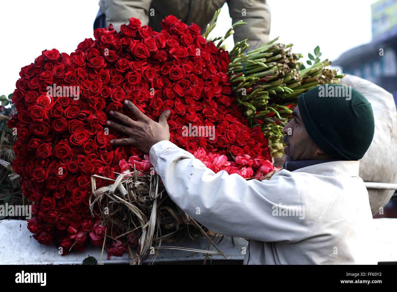Pakistani flower vendor display fresh roses and garlands to attract the ...