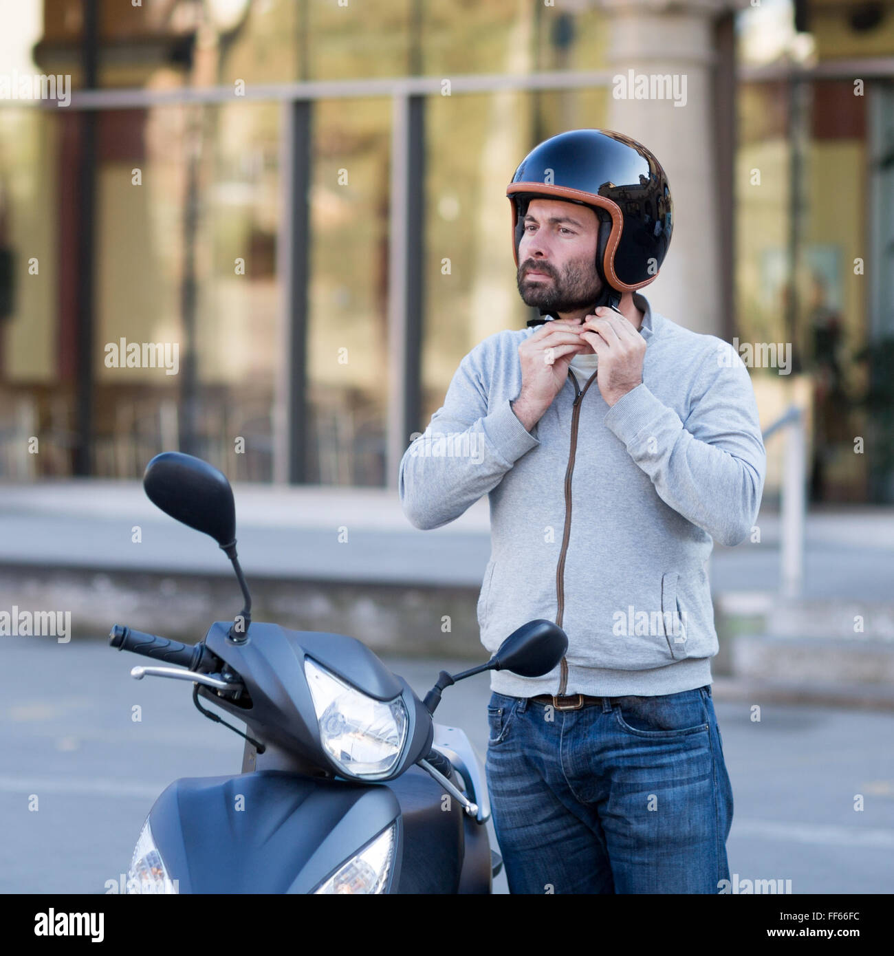 man with scooter takes off helmet Stock Photo - Alamy