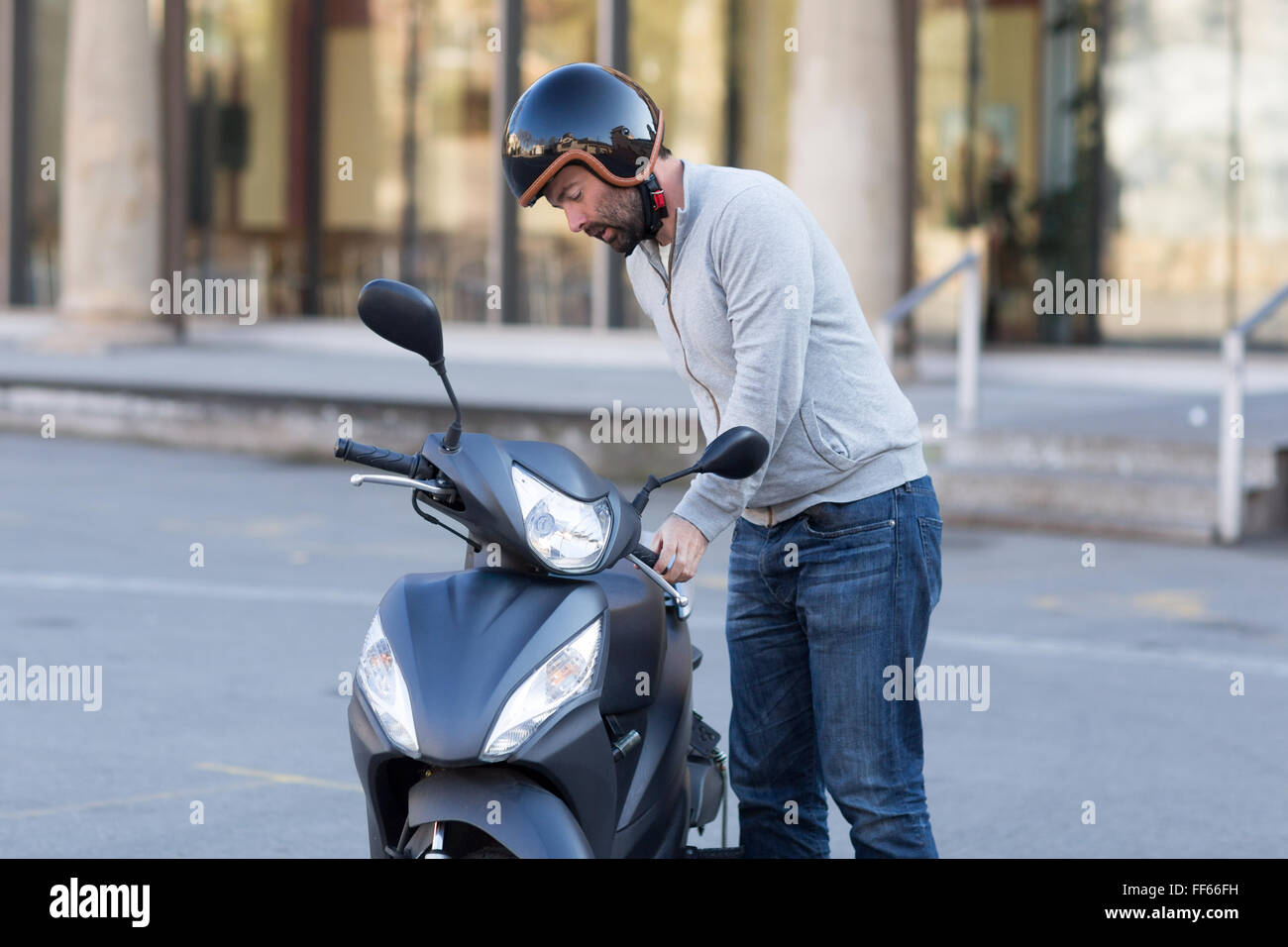 man checking scooter Stock Photo - Alamy