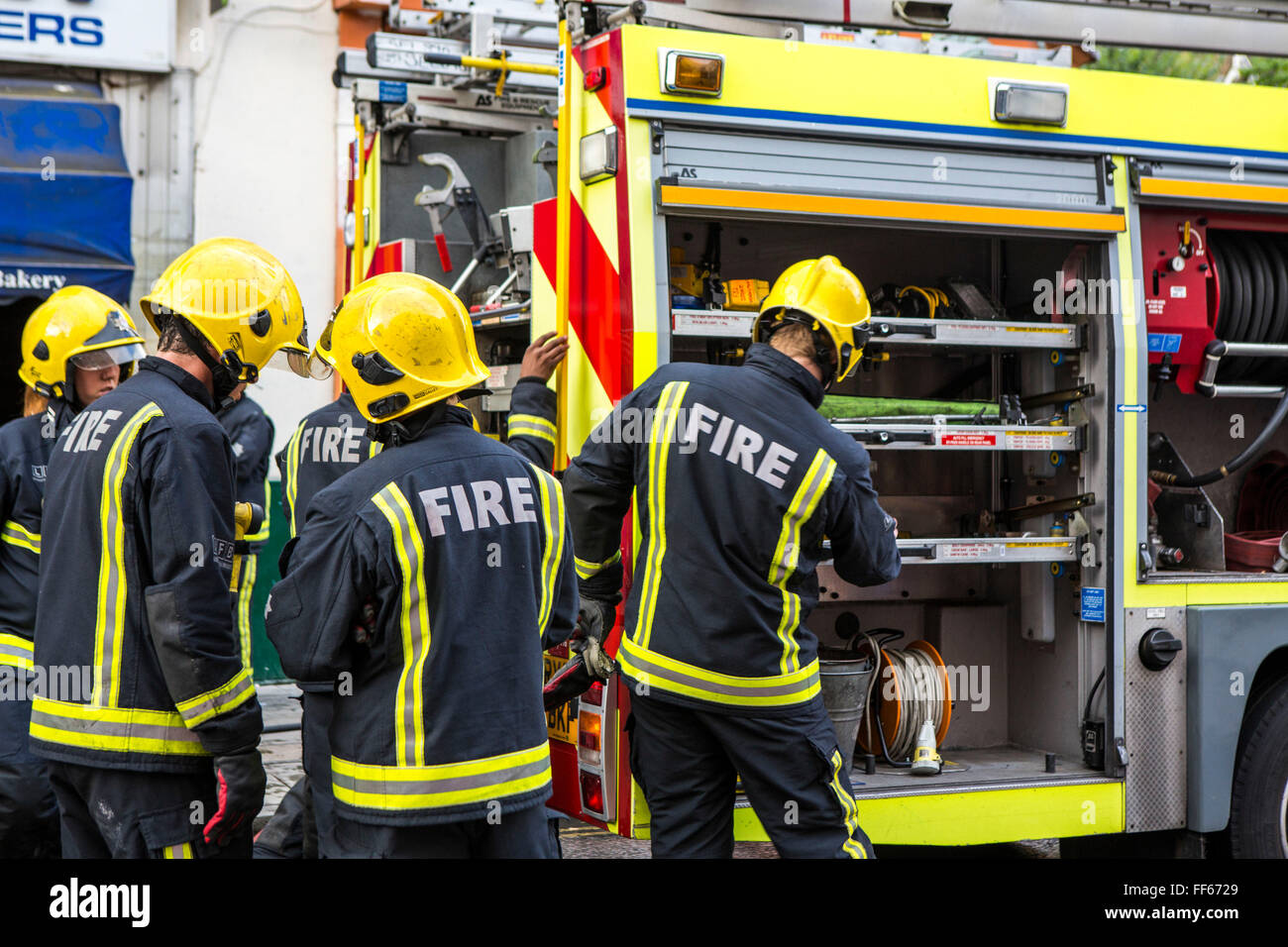 Firefighters from the London Fire Brigade gather by their fire engine ...