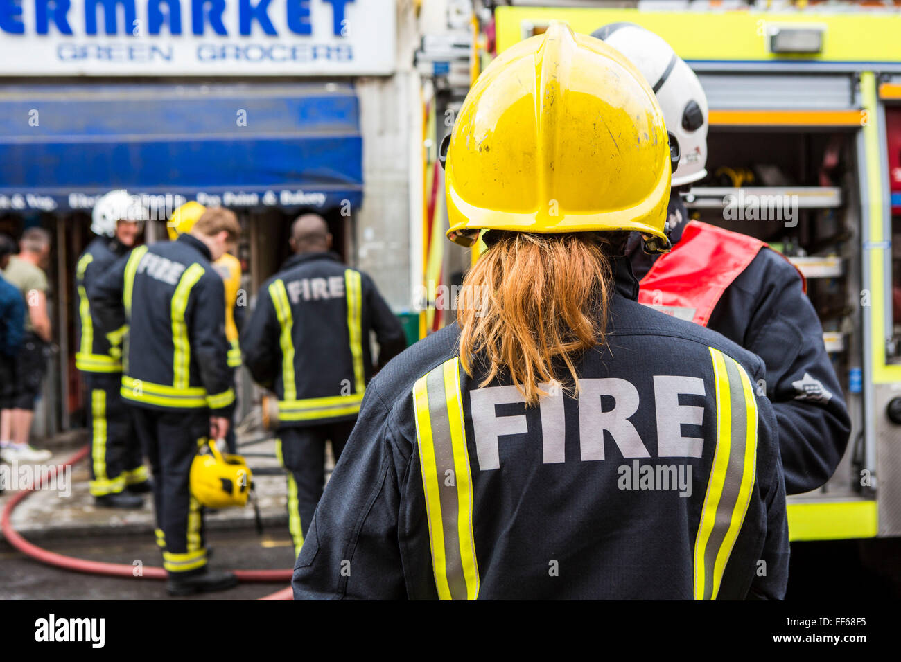 A female London Fire Brigade firefighter talks to the Sector Commander ...