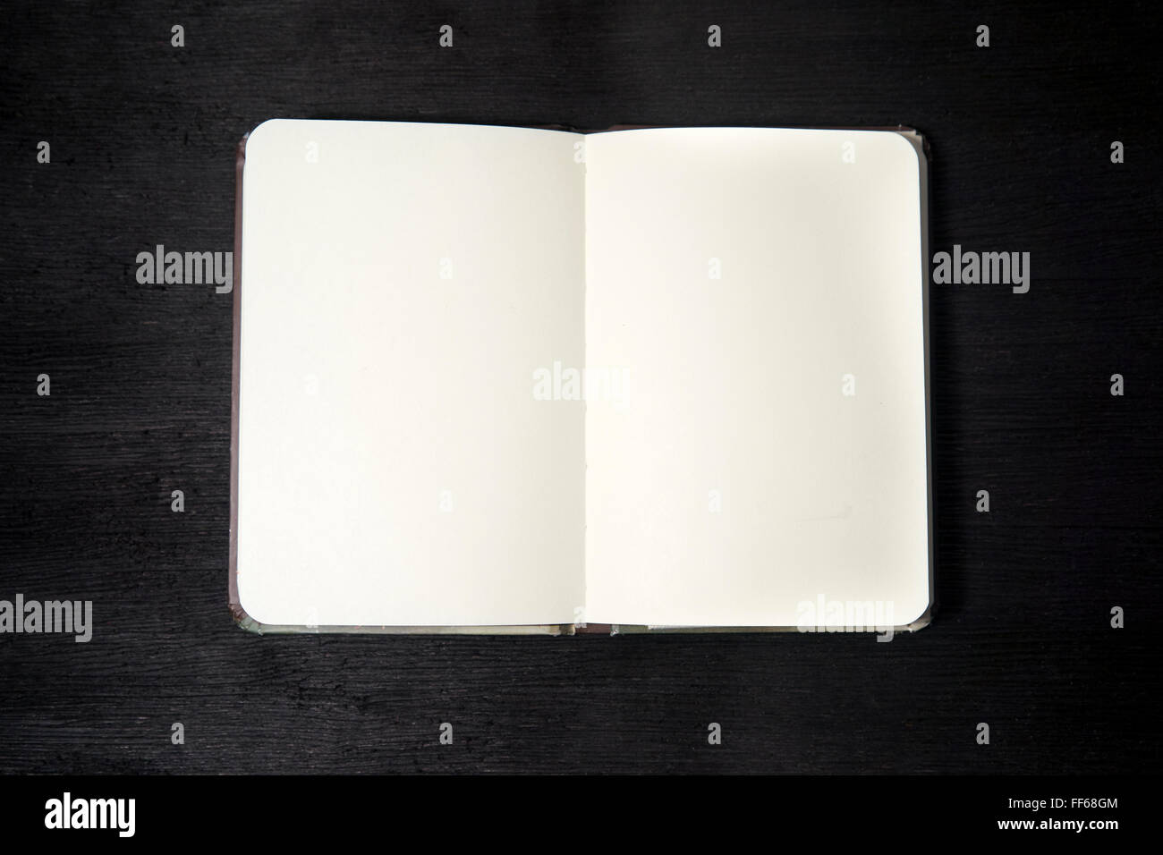 Open notebook isolated on black background Stock Photo - Alamy