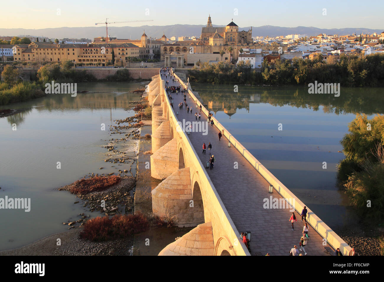 Roman bridge spanning river Rio Guadalquivir with Mezquita cathedral ...