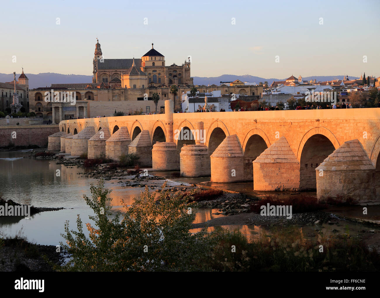 Roman bridge spanning river Rio Guadalquivir with Mezquita cathedral ...