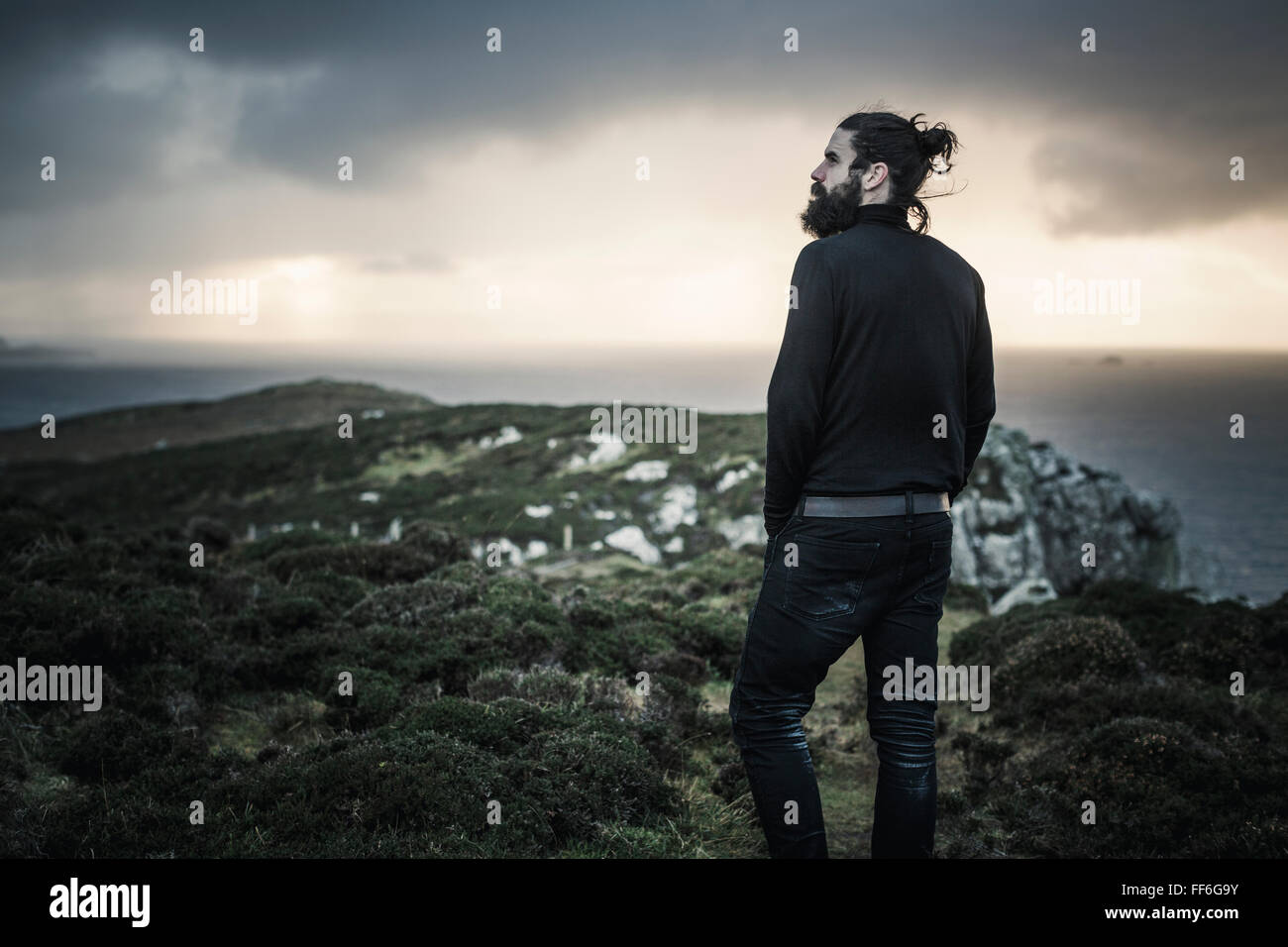 A man standing looking out over the landscape at sunset Stock Photo - Alamy