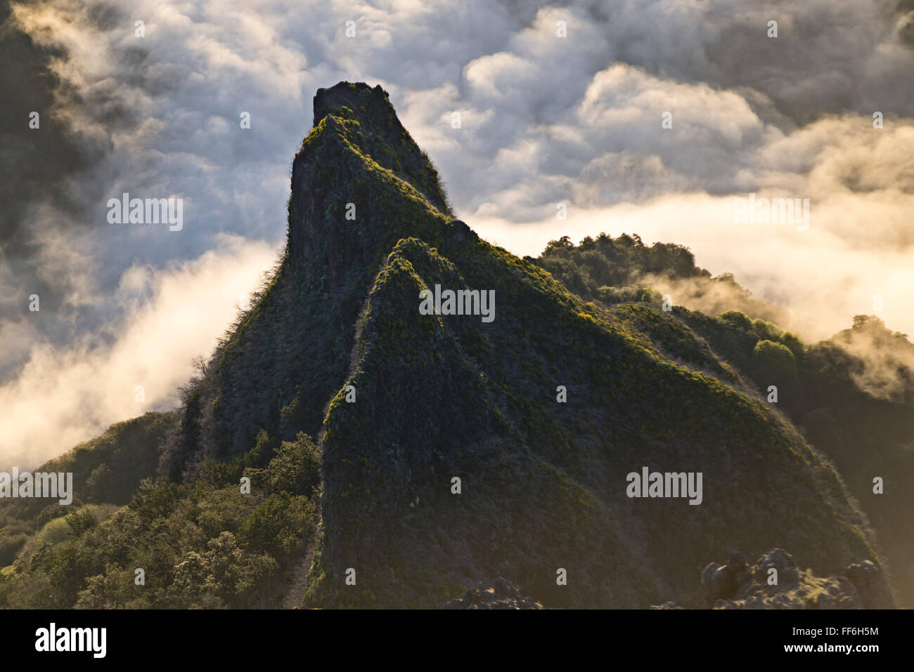 Sunrise over steep cliffs and peaks with the morning mist still ...