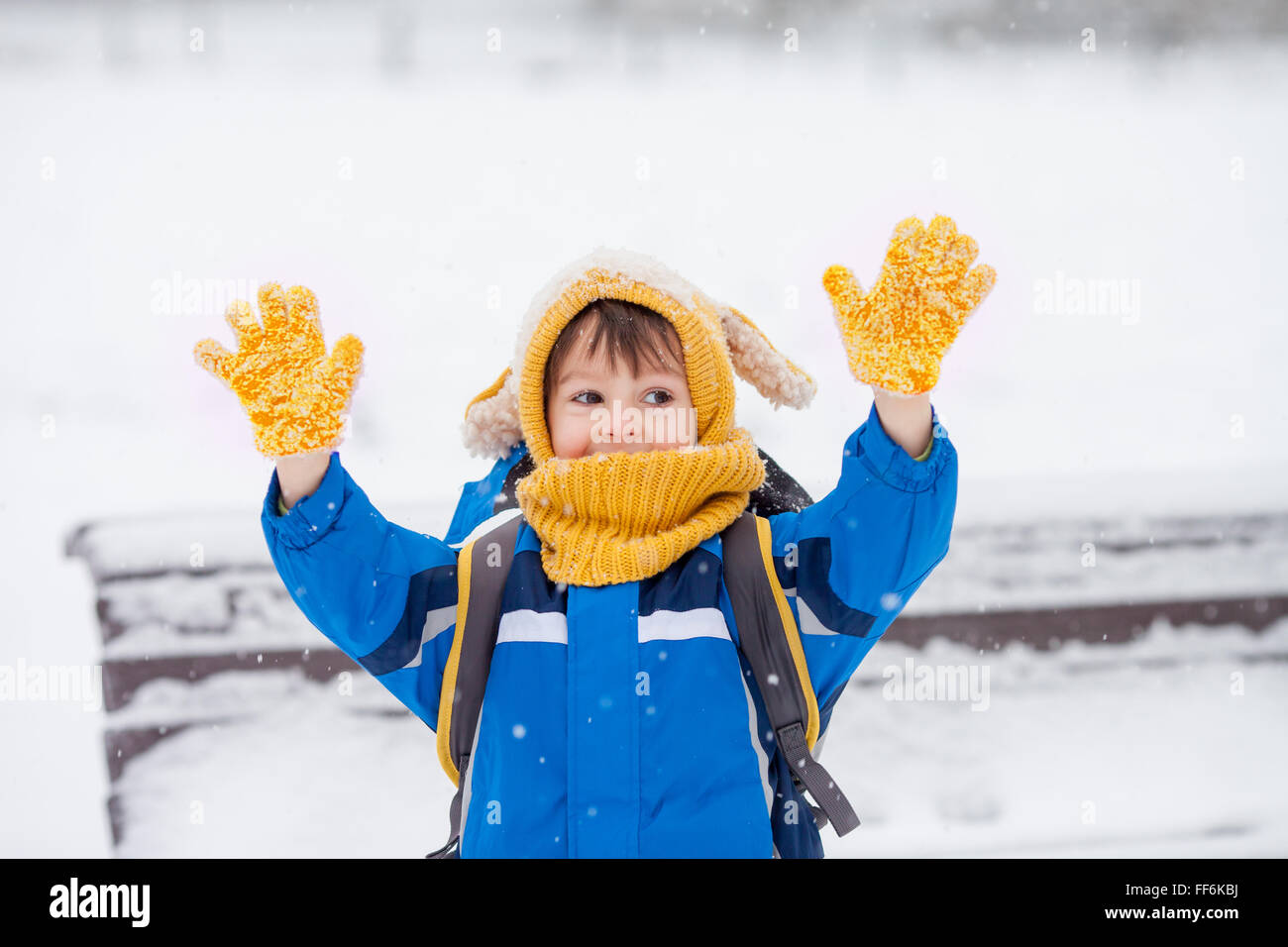 Cute little boy, catching snowflakes in the park on a winter day, heavy ...